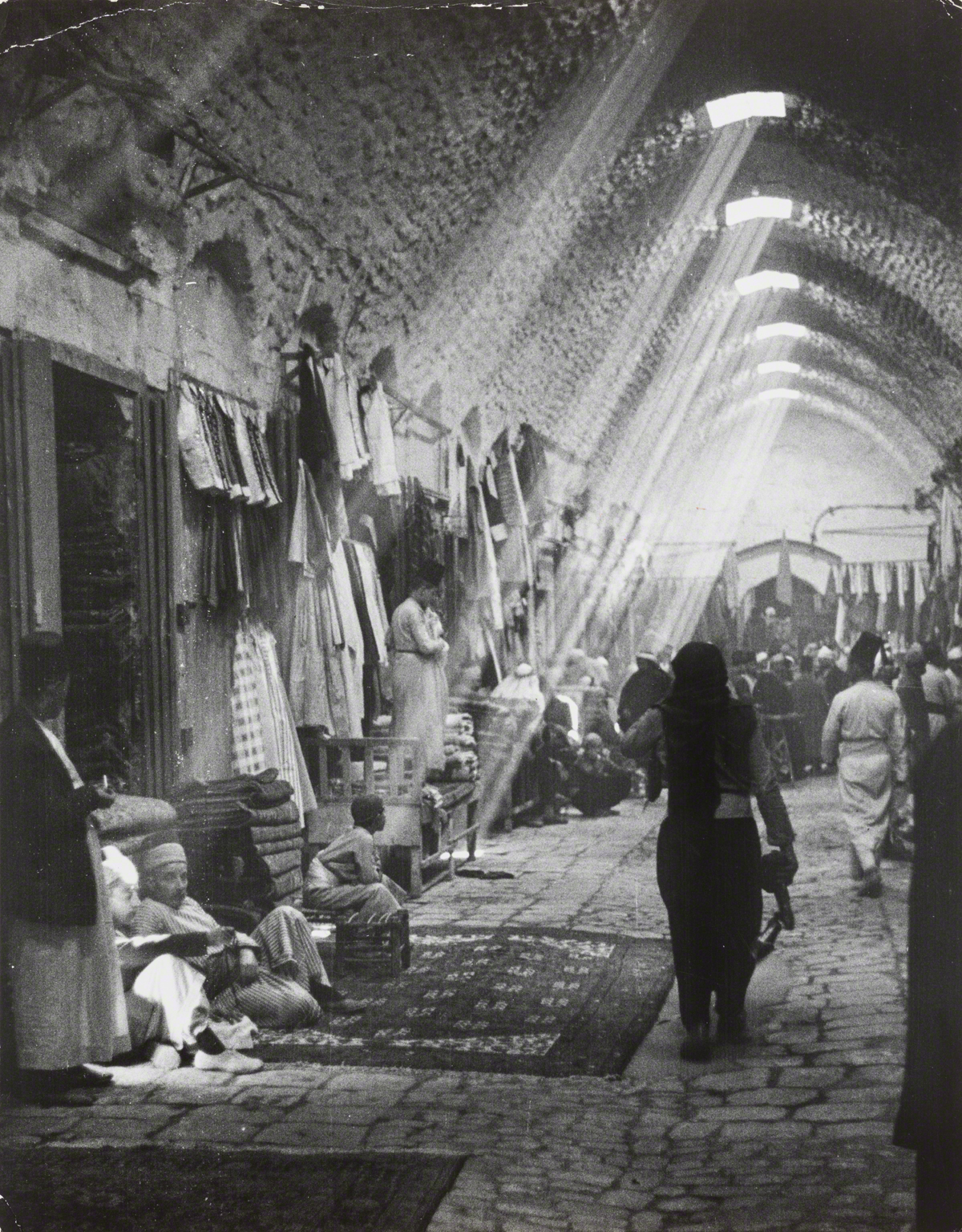 Sunlight streaming down from openings in a roof of covered bazaar ...